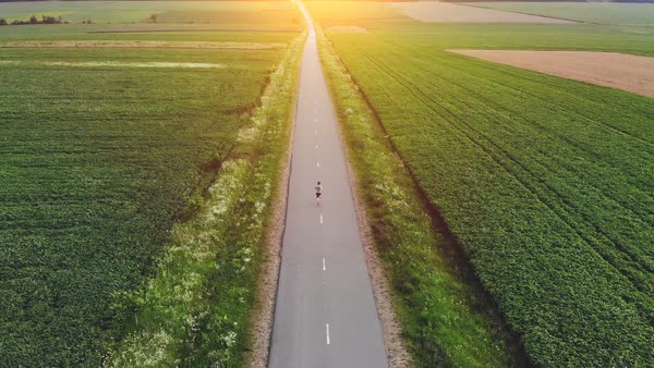 The sportsman running on a country road. quadrocopter shot - 4K Royalty ...