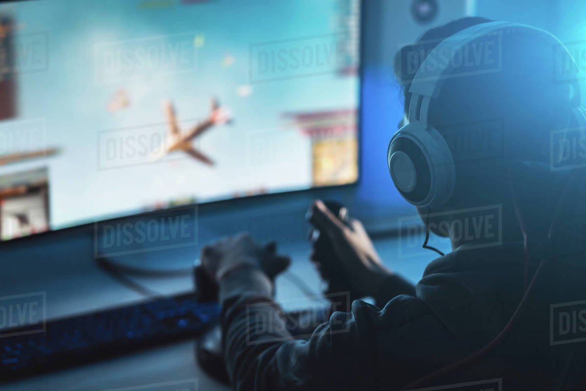 The guy gamer with headset playing video games on his personal computer ...