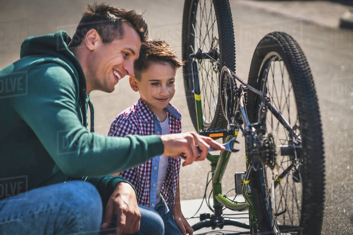 The father and son fixing the bicycle - Royalty-free Stock Photo | Dissolve