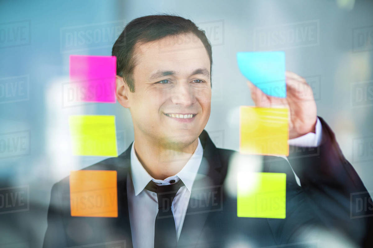 The businessman work with stickers on the window - Stock Photo - Dissolve