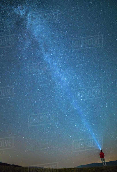 The man stand on the background of the stars in the sky. night time ...