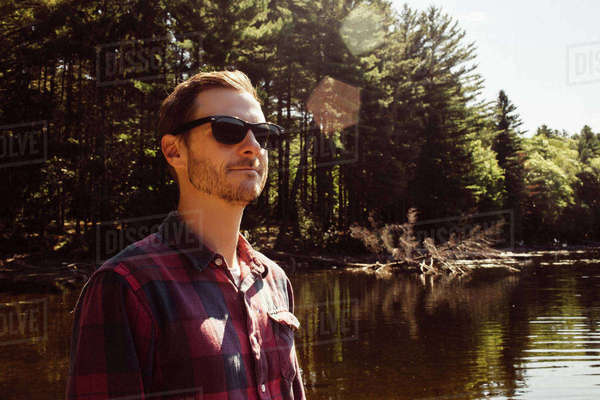 Man beside lake, looking at view - Royalty-free Stock Photo | Dissolve