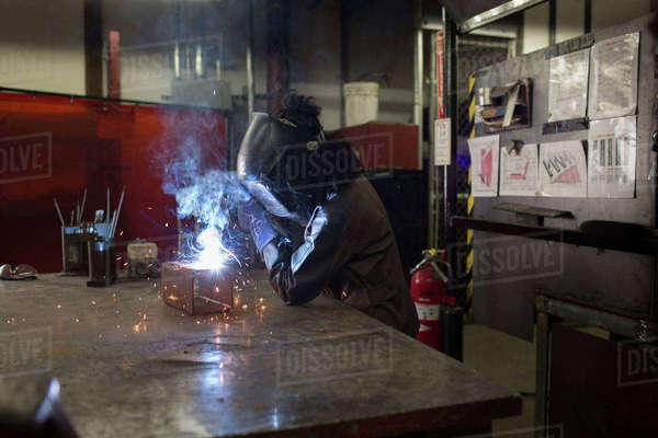 Female metalsmith welding metal box on workbench - Royalty-free Stock ...