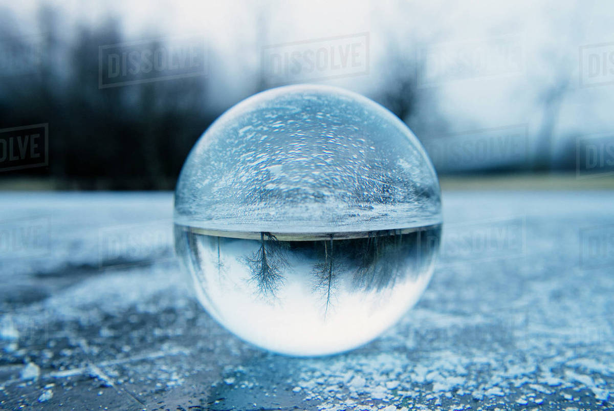 Close up of crystal ball on frozen lake - Stock Photo - Dissolve
