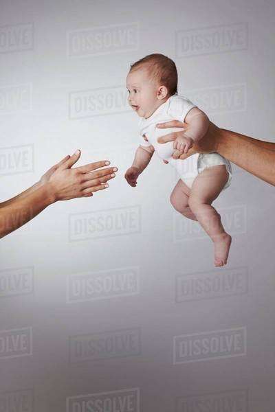 Parents passing baby daughter to each other - Royalty-free Stock Photo ...