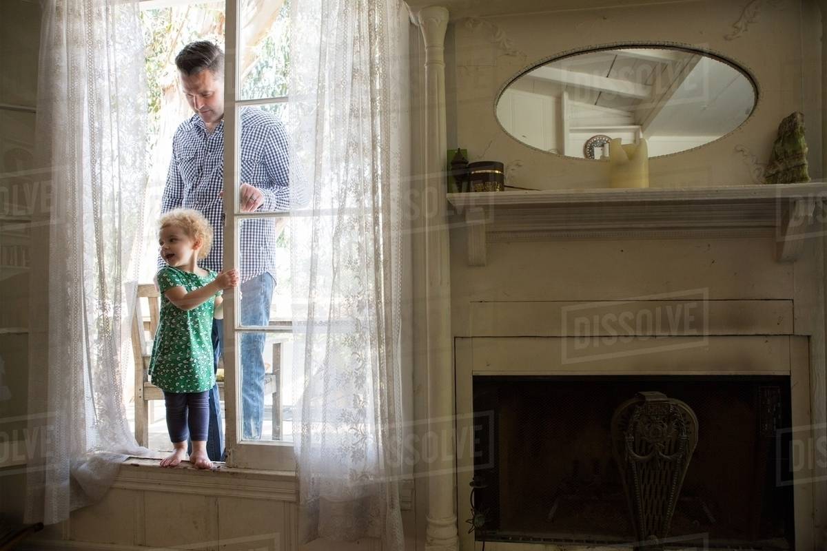 Father and child entering room from verandah - Stock Photo - Dissolve