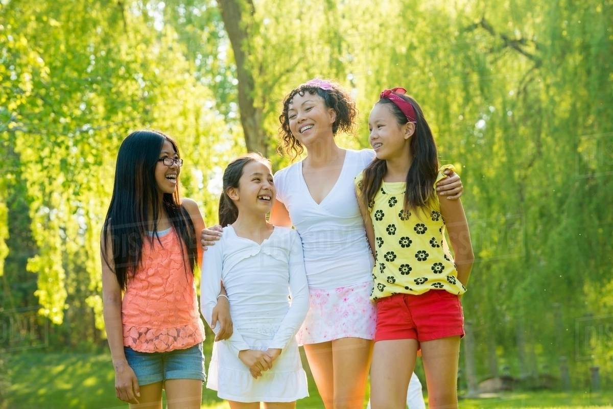 Woman with three girls in park - Royalty-free Stock Photo | Dissolve