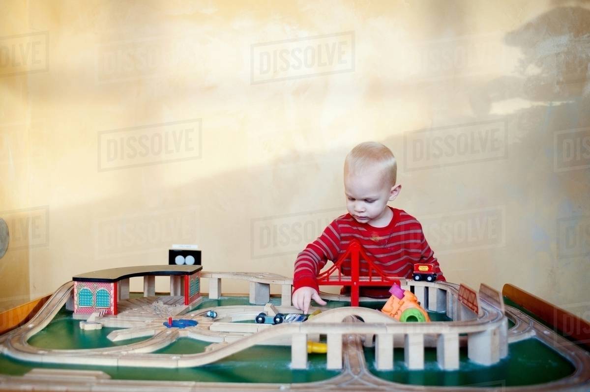 Young boy playing with toy train set - Royalty-free Stock Photo | Dissolve