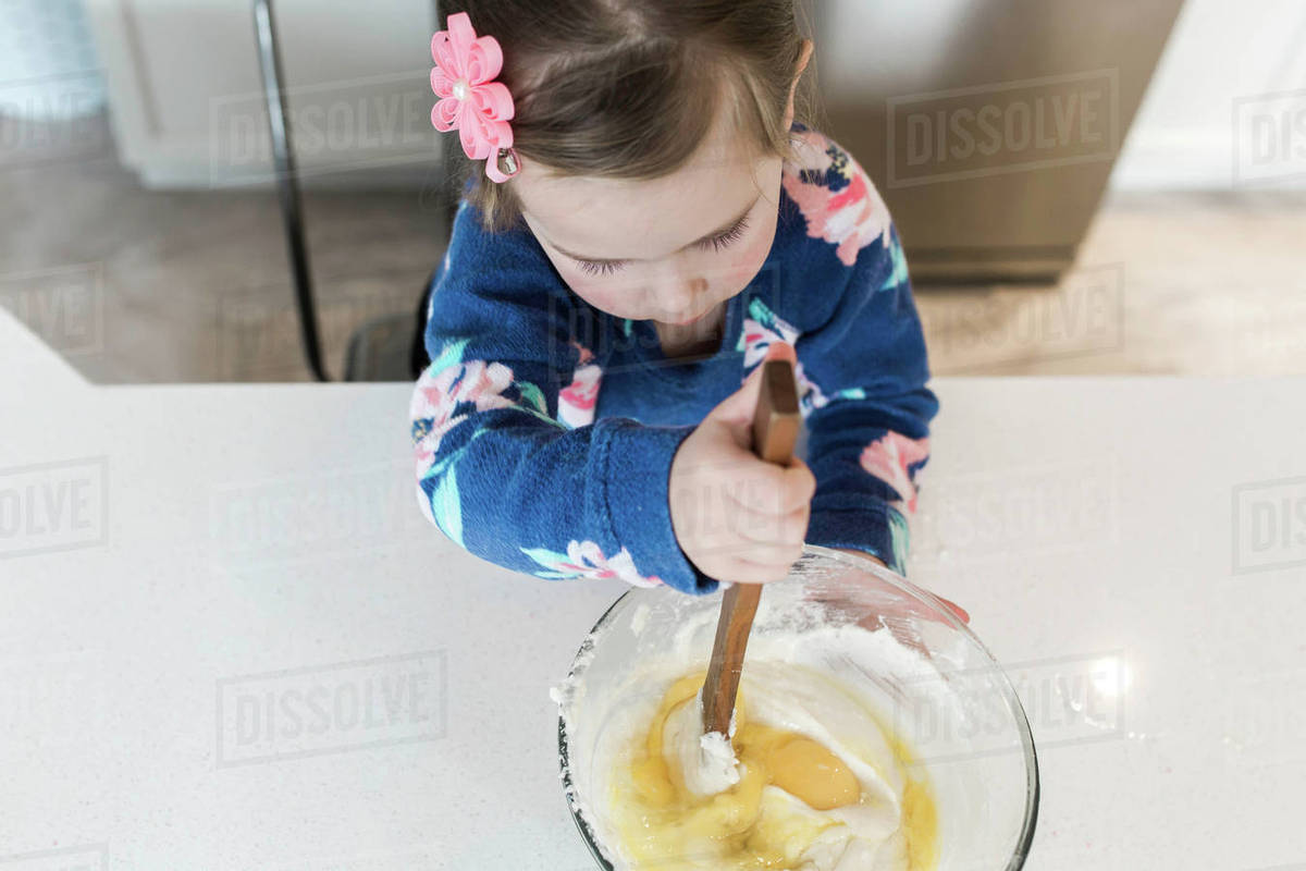 Overhead view of girl stirring mixing bowl at kitchen counter - Royalty ...