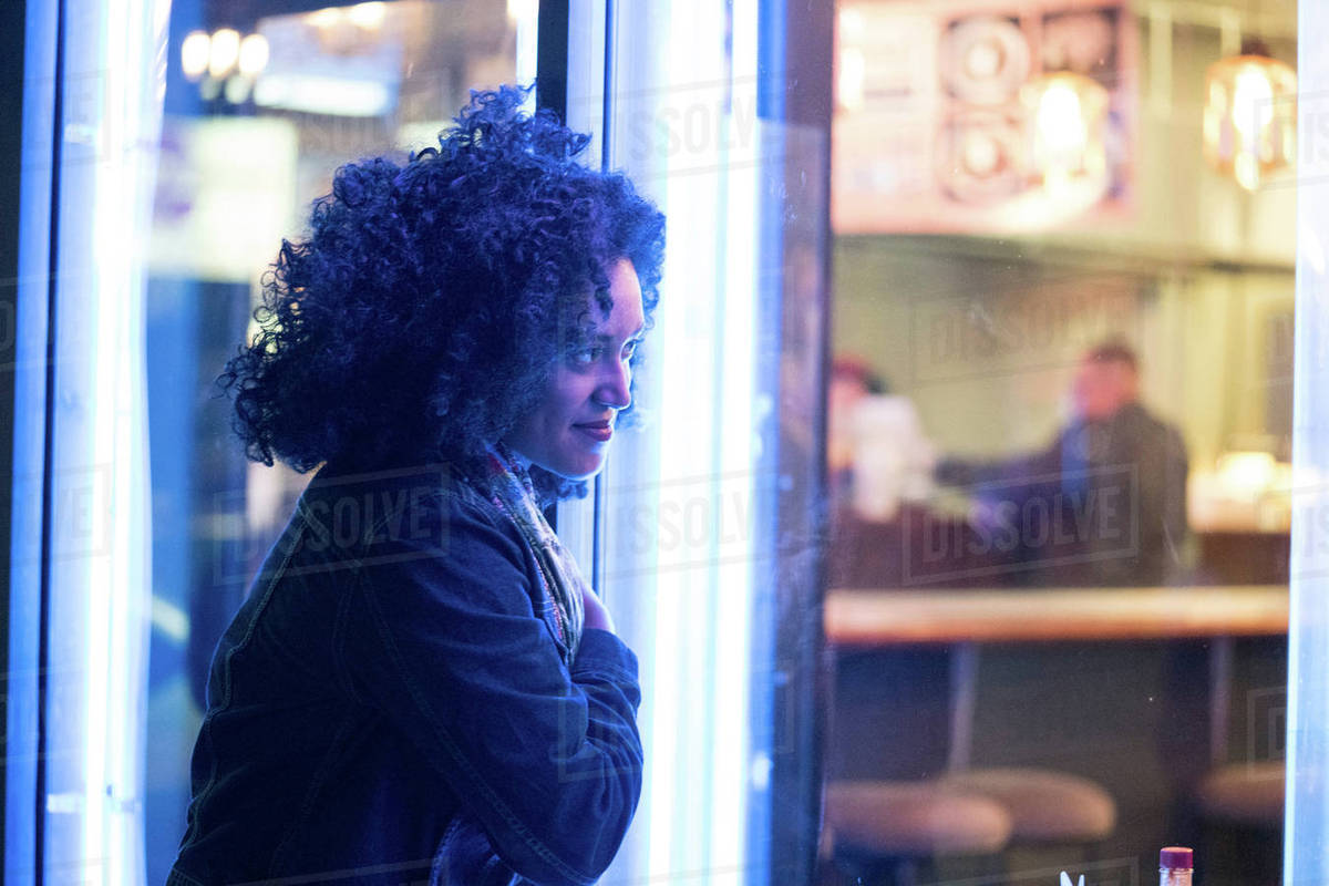Woman looking through cafe window at night - Royalty-free Stock Photo ...