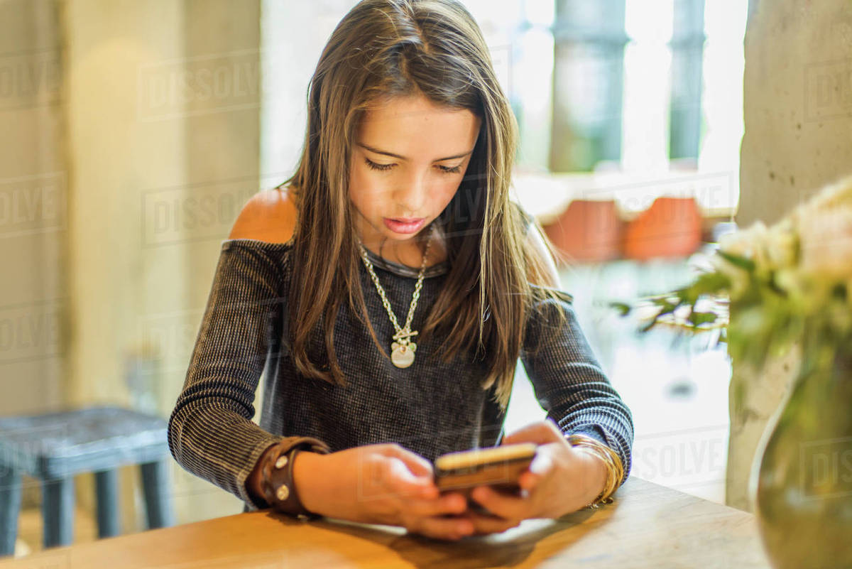 Girl texting on smartphone - Royalty-free Stock Photo | Dissolve