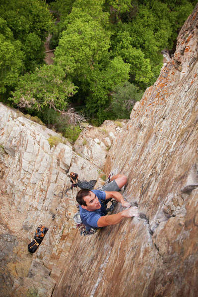 Rock climber scaling boulder crack - Royalty-free Stock Photo | Dissolve