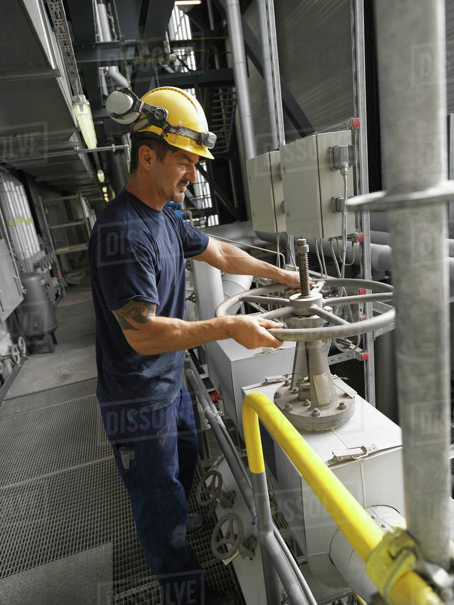 Worker operating machinery in factory - Royalty-free Stock Photo | Dissolve