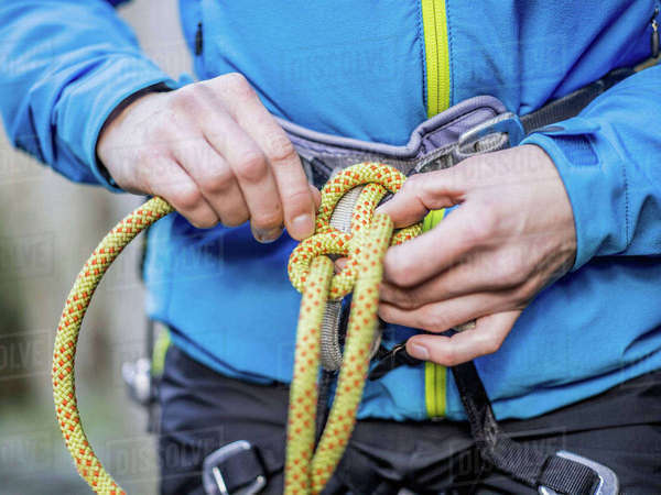 Rock climber tying rope - Royalty-free Stock Photo | Dissolve