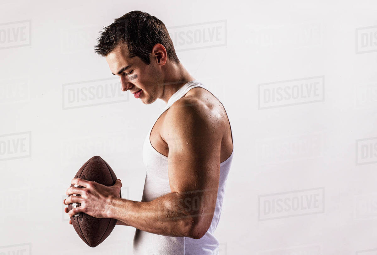 Athletic man holding football - Stock Photo - Dissolve