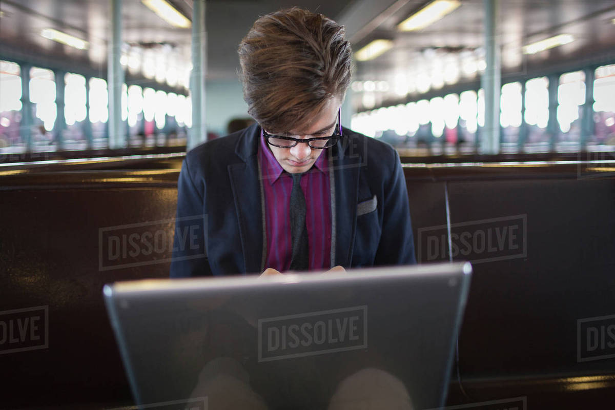 Businessman on laptop in train station - Royalty-free Stock Photo ...
