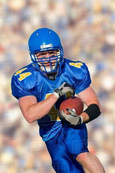 American footballer running with ball - Royalty-free Stock Photo | Dissolve