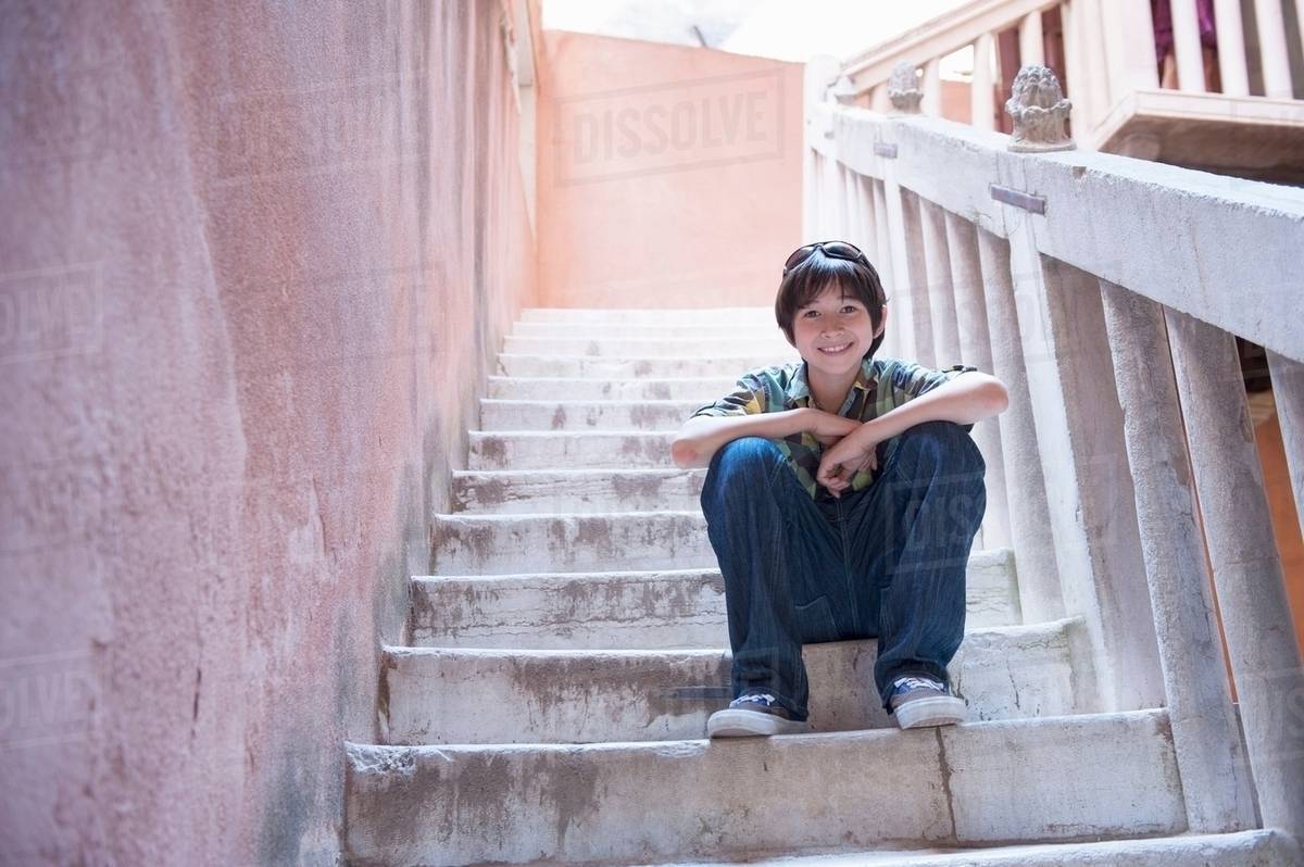 Boy sitting on steps - Stock Photo - Dissolve