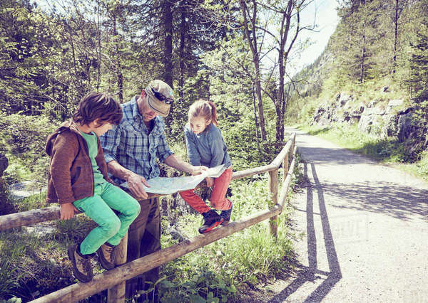 Father and children in forest, looking at map - Royalty-free Stock ...