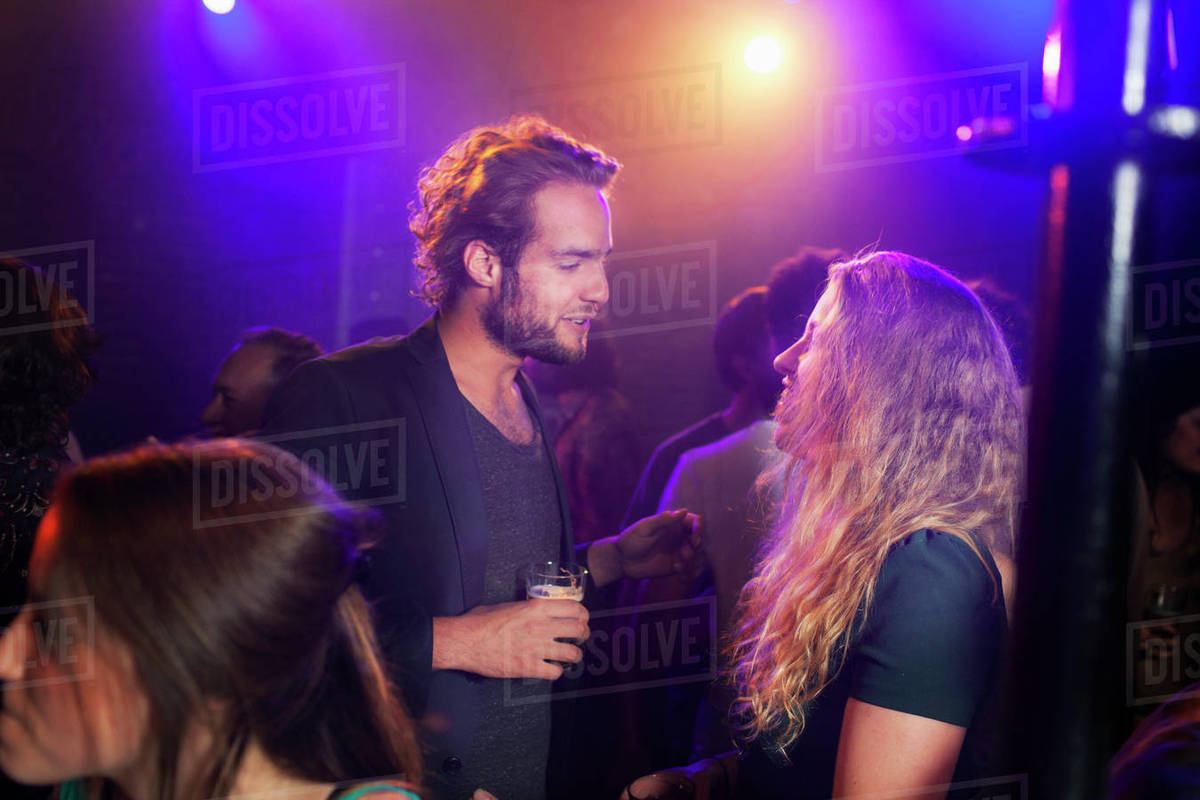 Young couple chatting in club - Royalty-free Stock Photo | Dissolve
