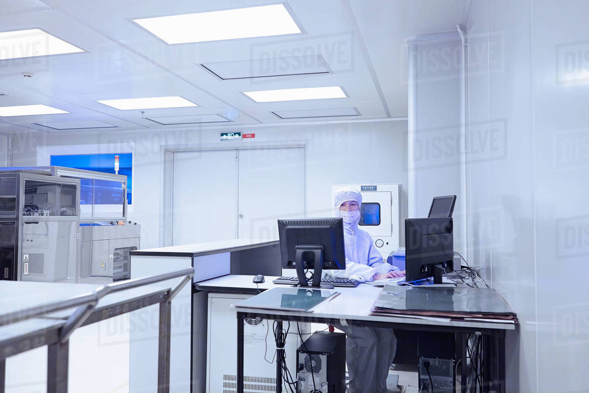 Female factory worker using computers in flexible electronics factory ...