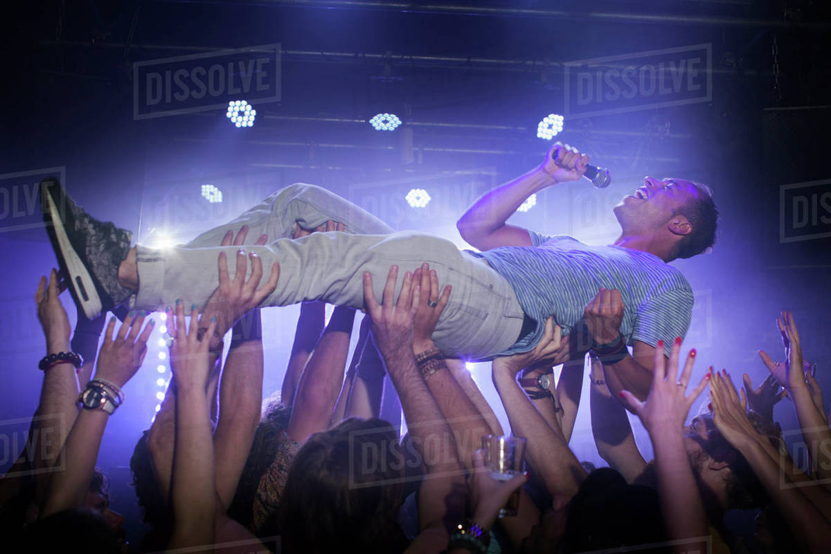 Group of people lifting man in club - Royalty-free Stock Photo | Dissolve