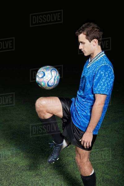 Young man with soccer ball on pitch - Stock Photo - Dissolve
