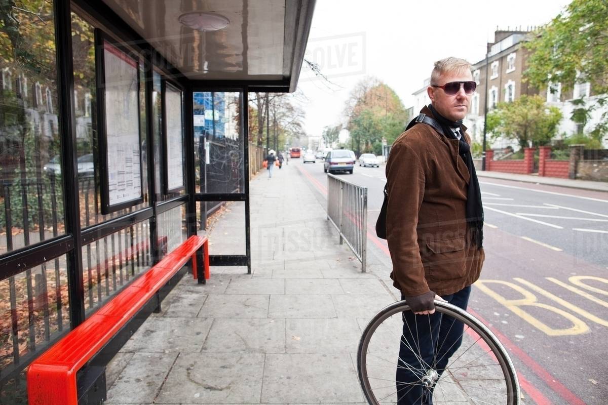 Cyclist waiting at bus stop - Royalty-free Stock Photo | Dissolve