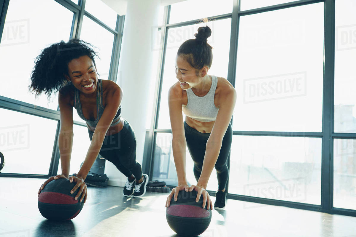 Two young women working out in gym, using gym equipment - Stock Photo ...