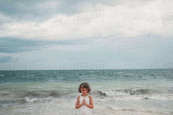 Girl praying on beach, Cancun, Mexico - Royalty-free Stock Photo | Dissolve