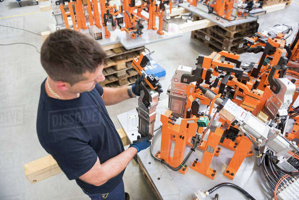 Factory worker looking at product in engineering factory - Stock Photo ...