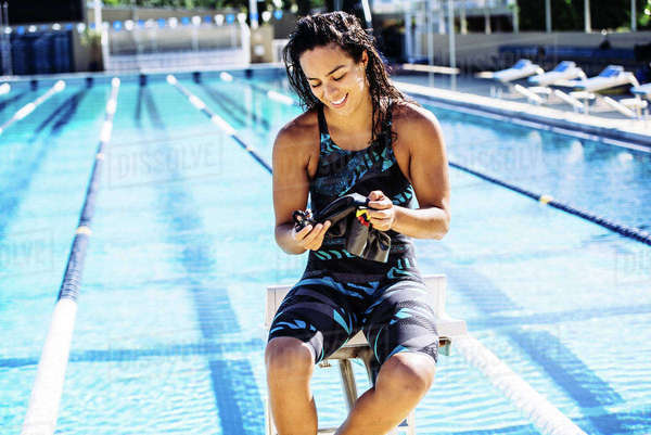 Swimmer sitting at end of pool - Stock Photo - Dissolve
