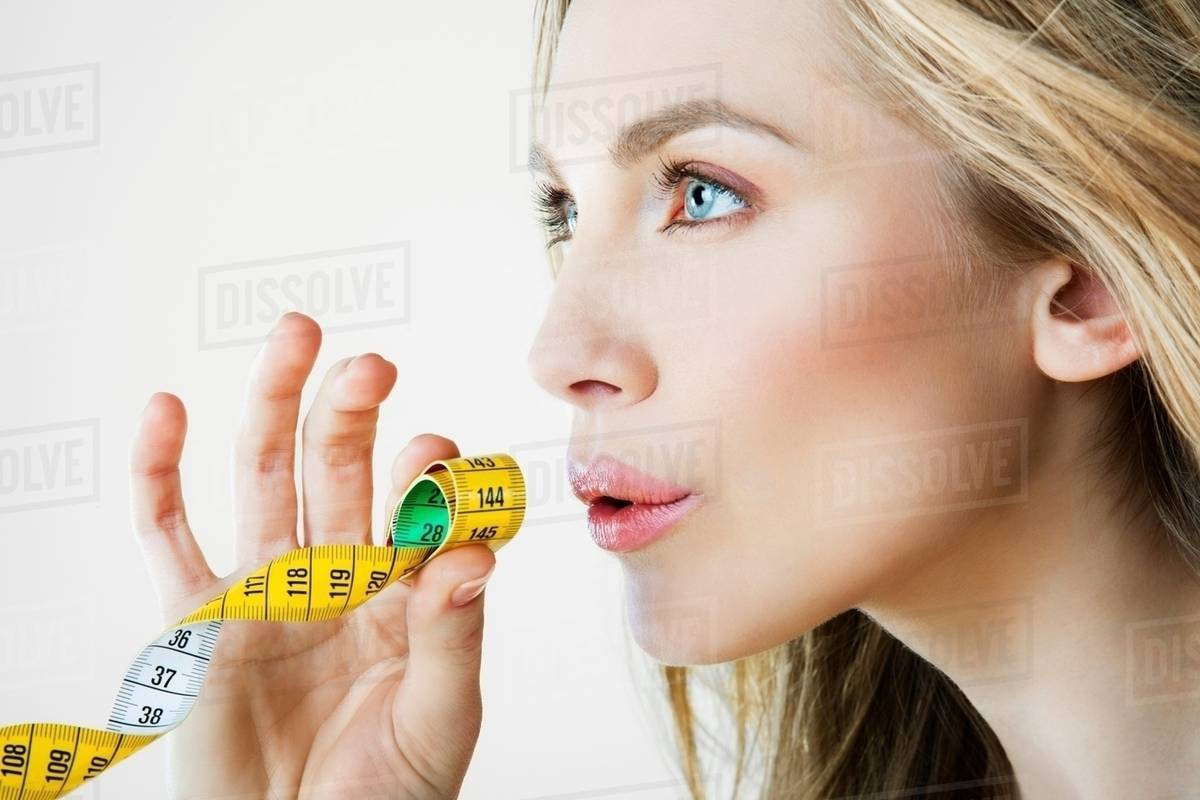 Young woman holding tape measure, close up - Royalty-free Stock Photo ...