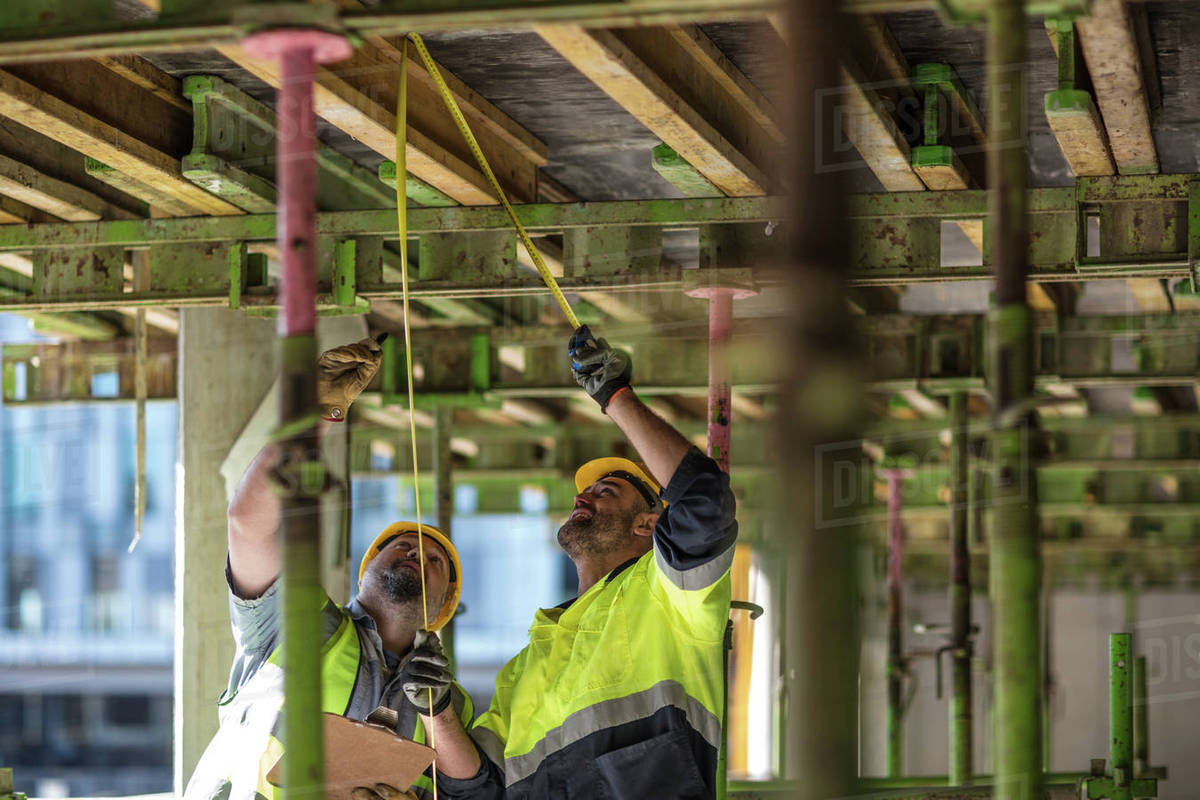 Construction workers measuring building - Royalty-free Stock Photo ...