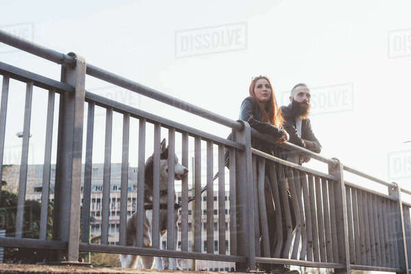 Couple leaning against railings looking away - Royalty-free Stock Photo ...