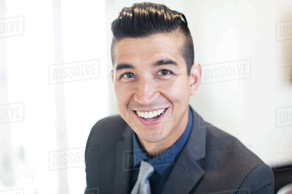 Portrait of smiling young businessman in office - Stock Photo - Dissolve