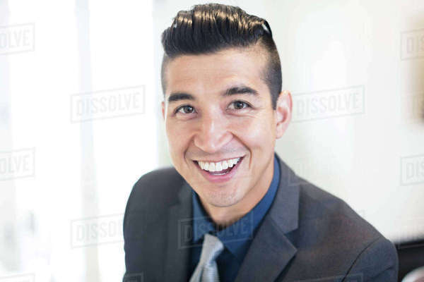 Portrait of smiling young businessman in office - Stock Photo - Dissolve