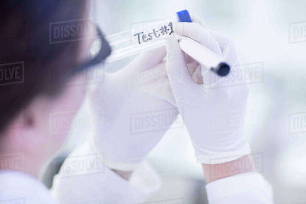 Laboratory worker writing details on test tube, rear view - Royalty ...