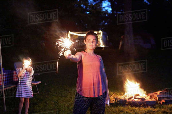 Two girls standing near camp fire, using sparklers - Royalty-free Stock ...