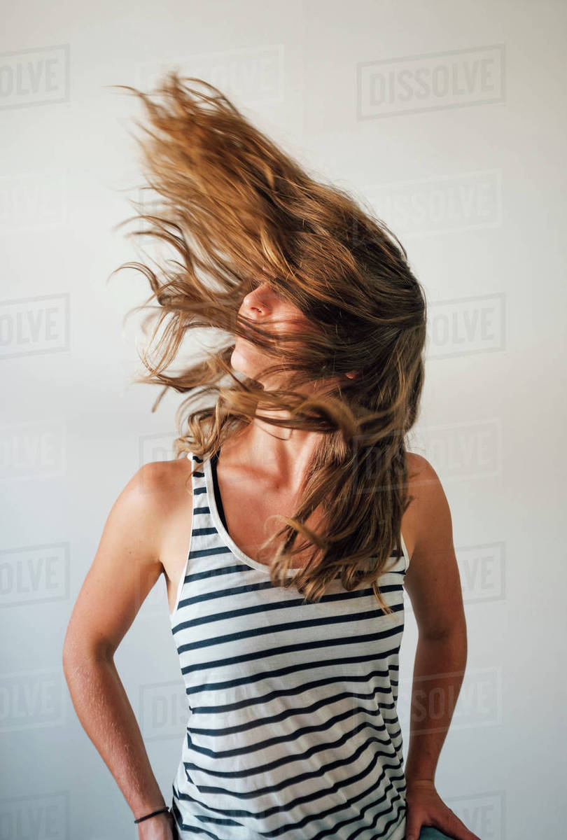 Young woman throwing head back - Stock Photo - Dissolve