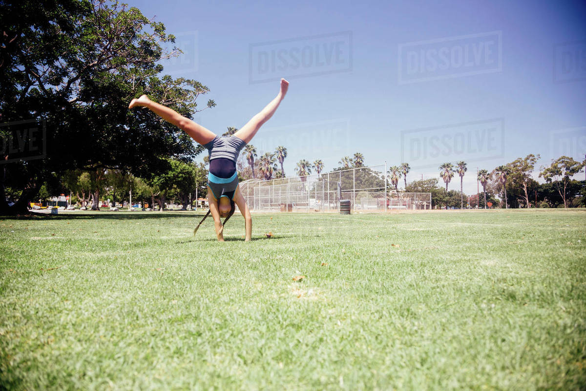 Schoolgirl doing cartwheel on school sports field - Royalty-free Stock ...