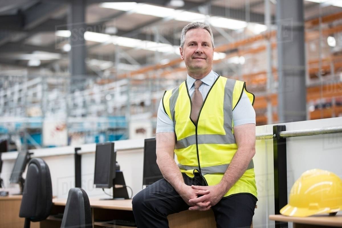 Man sitting on desk in warehouse, portrait - Royalty-free Stock Photo ...
