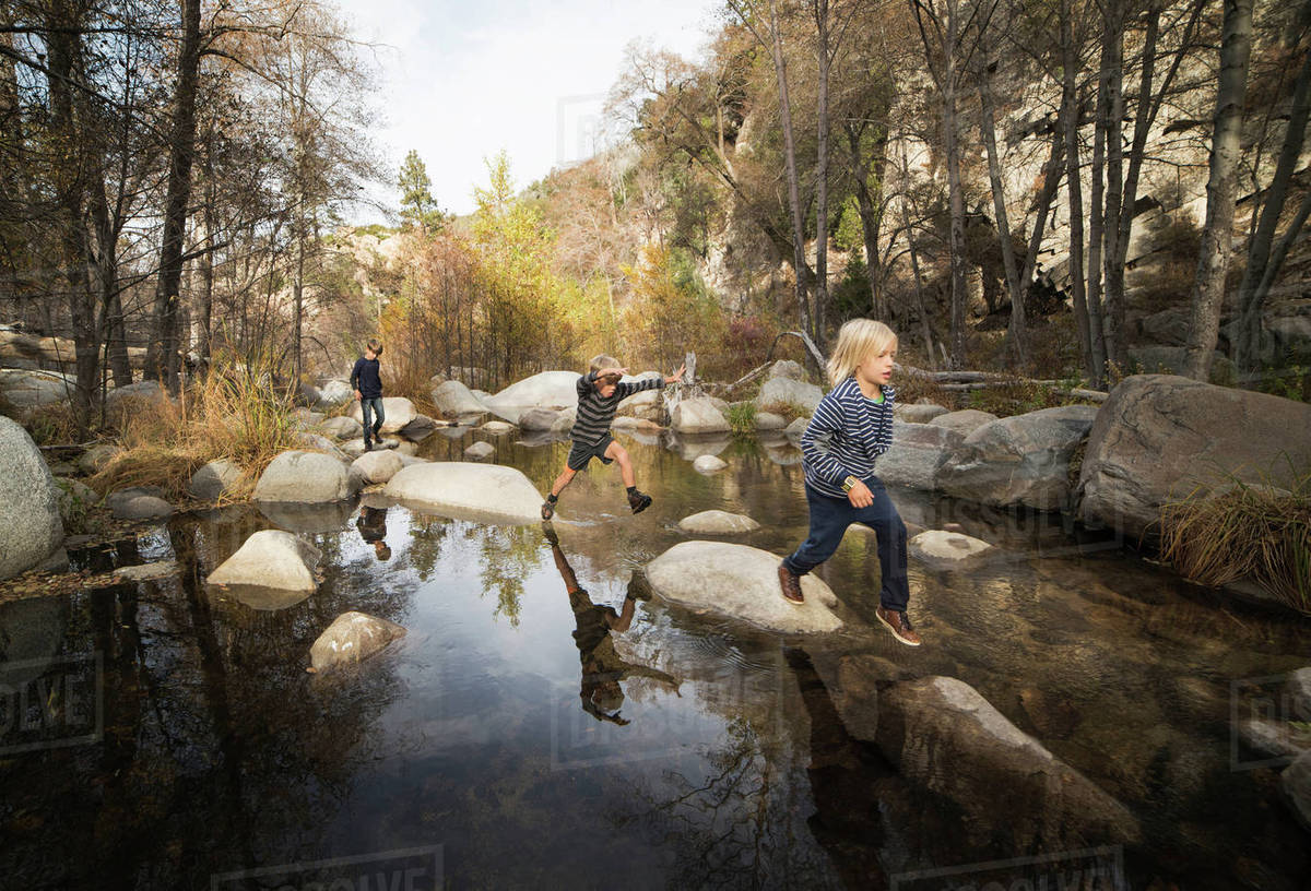 Children playing on rocks in river, Lake Arrowhead, California, USA ...