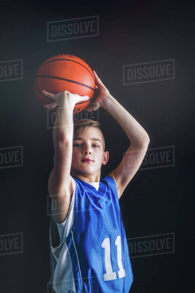 Boy throwing basketball - Stock Photo - Dissolve