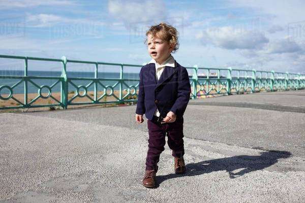 Little boy walking promenade in mod clothing - Stock Photo - Dissolve