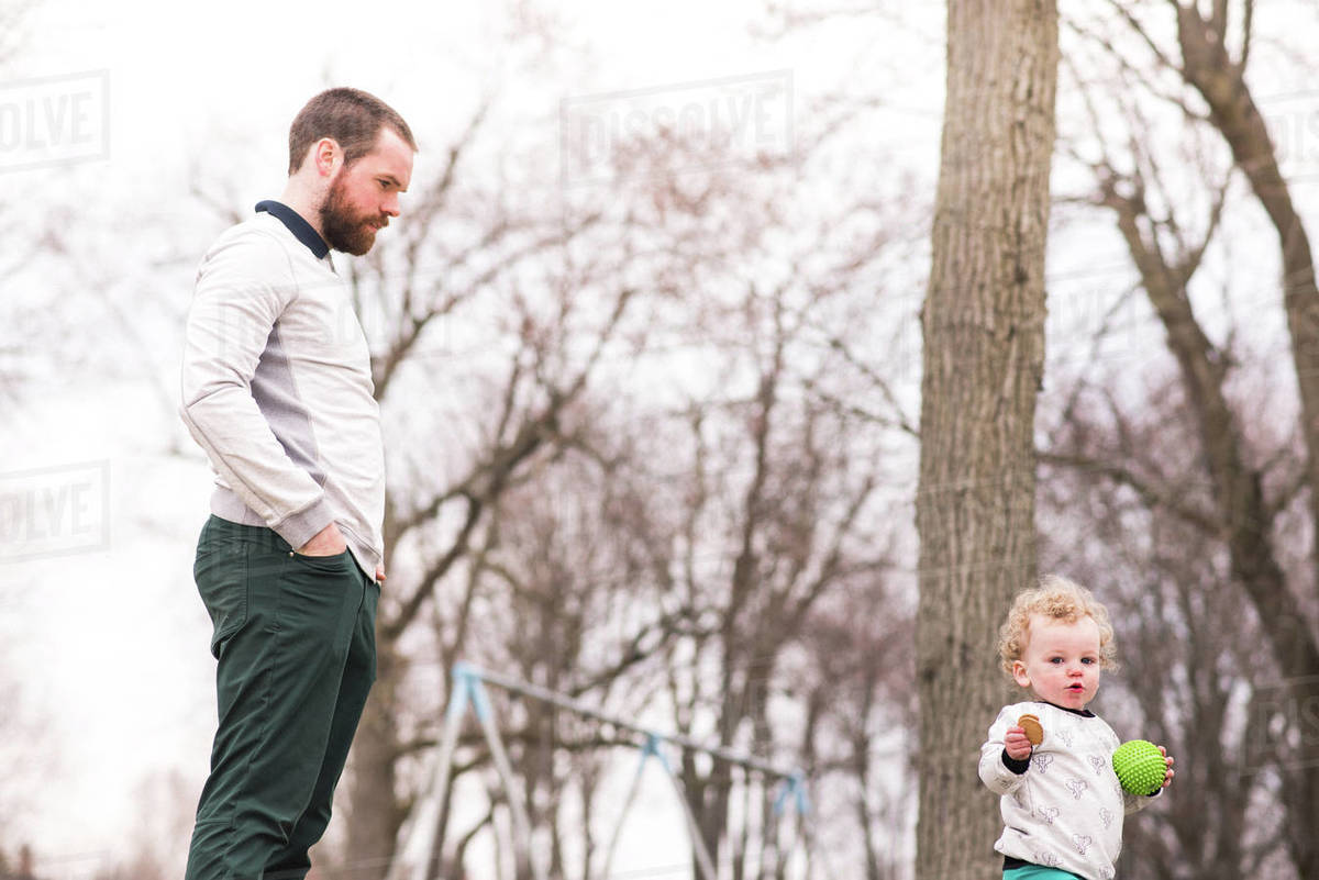 Father watching over son in park - Royalty-free Stock Photo | Dissolve