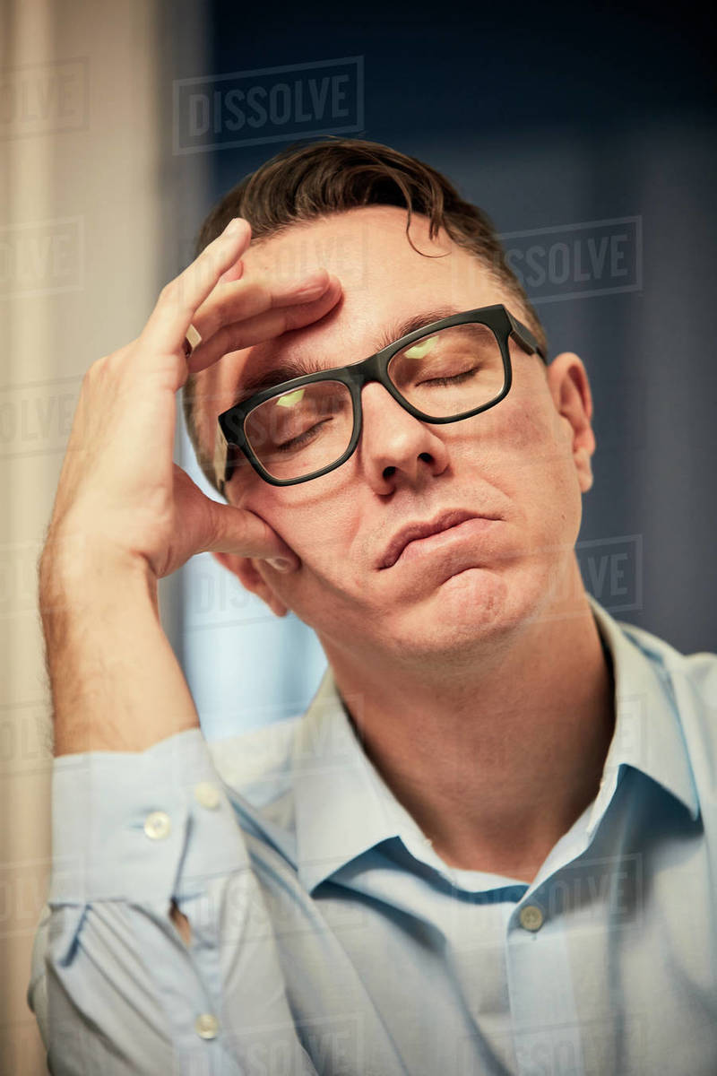 Man resting on elbow with eyes closed - Royalty-free Stock Photo | Dissolve