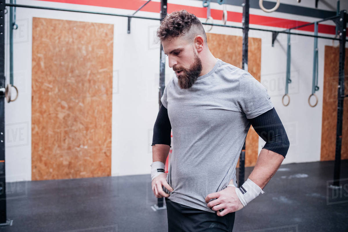 Exhausted young man taking break in gym - Royalty-free Stock Photo ...