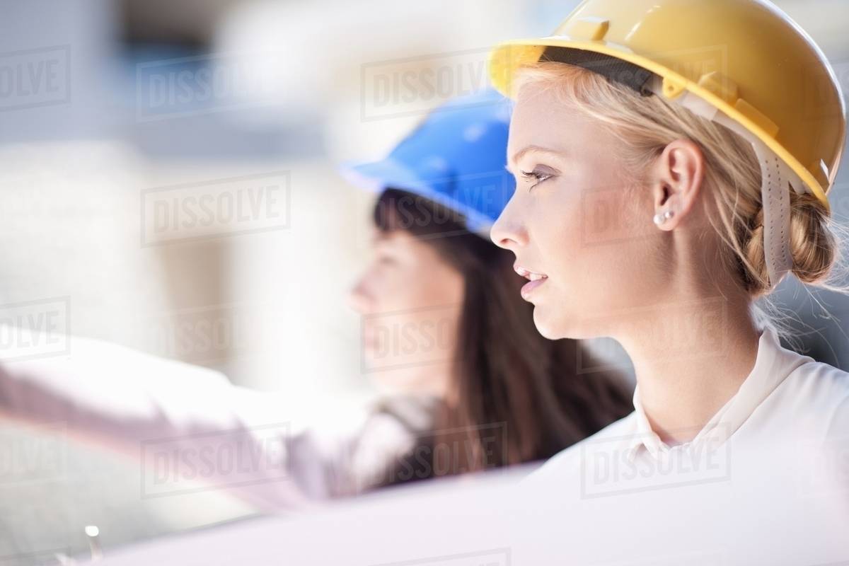 Businesswomen reading blueprints - Royalty-free Stock Photo | Dissolve
