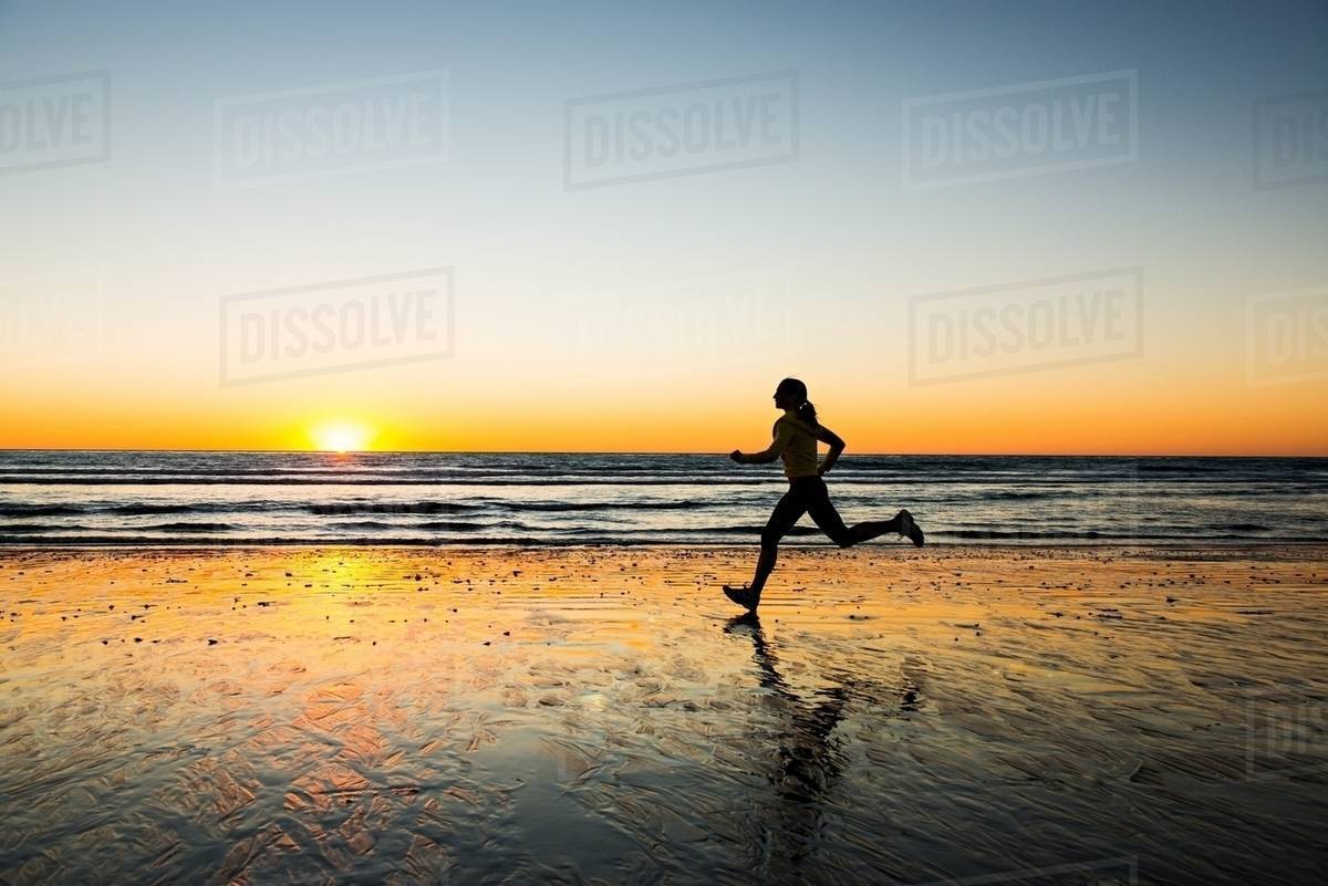 Woman running on beach - Stock Photo - Dissolve